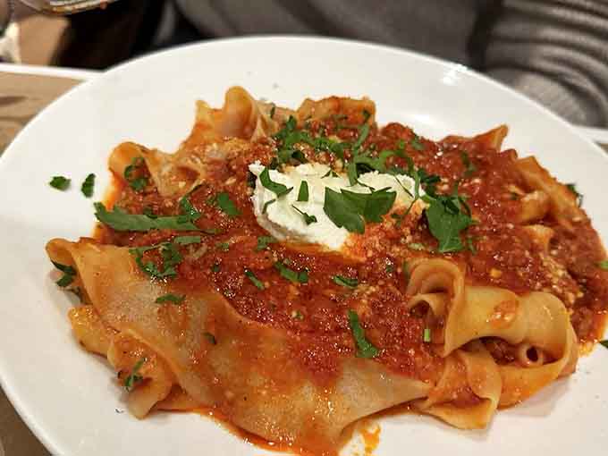 Fresh pappardelle ribbons catching every drop of bolognese like they were designed by Italian engineers who really understood their assignment.