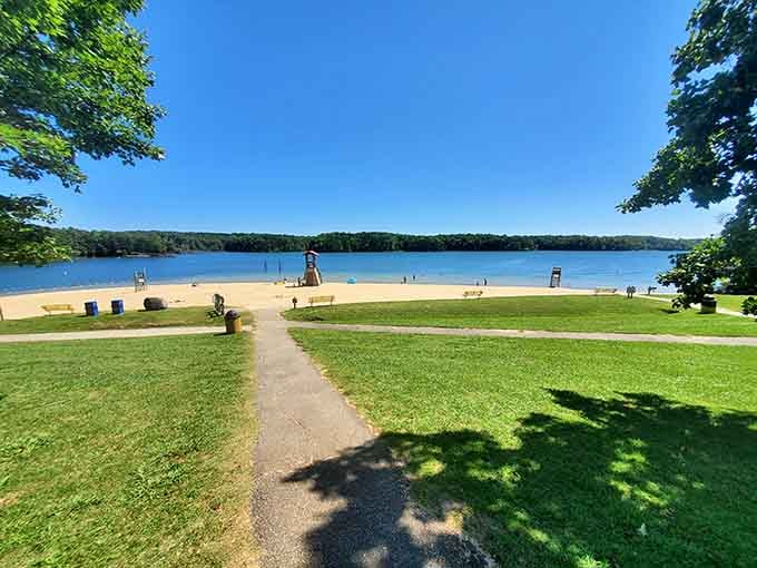 The walking path invites leisurely strolls between shade and sunshine, perfect for contemplative beach wandering.