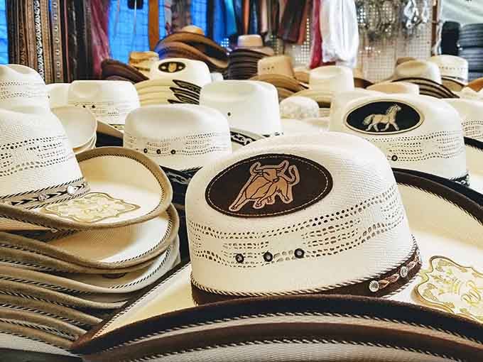 Woven straw cowboy hats rest peacefully, their decorative bands and emblems whispering tales of rodeos and summer festivals.