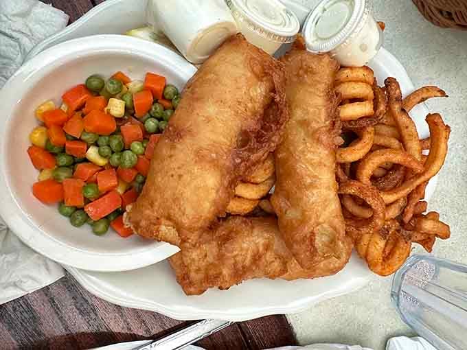 Beer-battered cod and curly fries proving that sometimes the best seafood is found miles from any ocean.