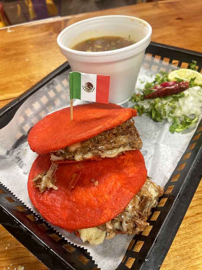 Birria gorditas with bright red tortillas that look like they teleported straight from a fever dream into reality.