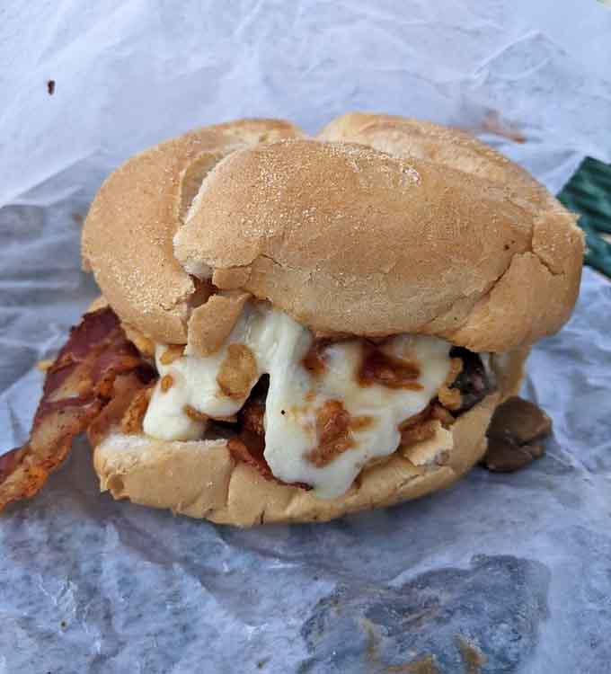 Bacon peeking out from under a generous cheese pour on a soft roll, this creation understands exactly what breakfast-for-lunch should look like.