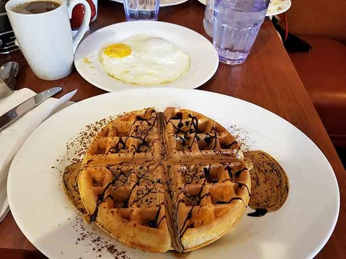 A waffle drizzled with chocolate that makes you question whether this counts as breakfast or dessert therapy.