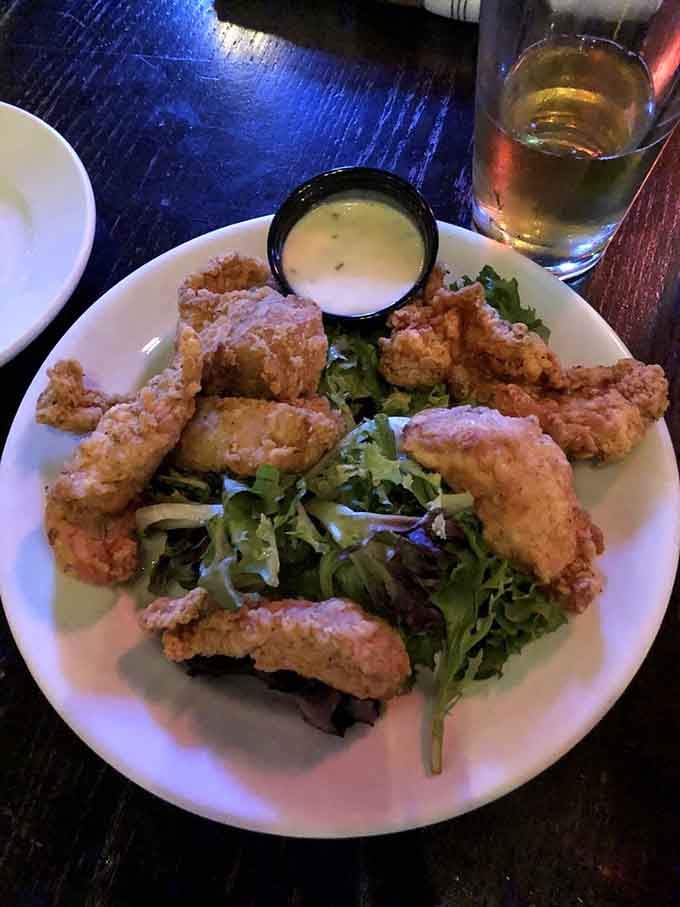 Crispy chicken tenders served over fresh greens, because sometimes you want your comfort food to at least pretend it's virtuous.
