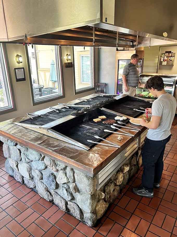 That rustic stone grill station where steaks sizzle in plain view beats any cooking show you've ever binge-watched on TV.