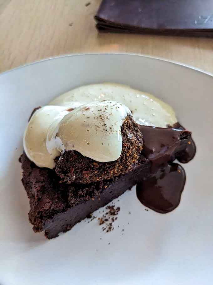 Chocolate cake topped with cream becomes the sweet finale your meal deserves, rich and utterly satisfying.