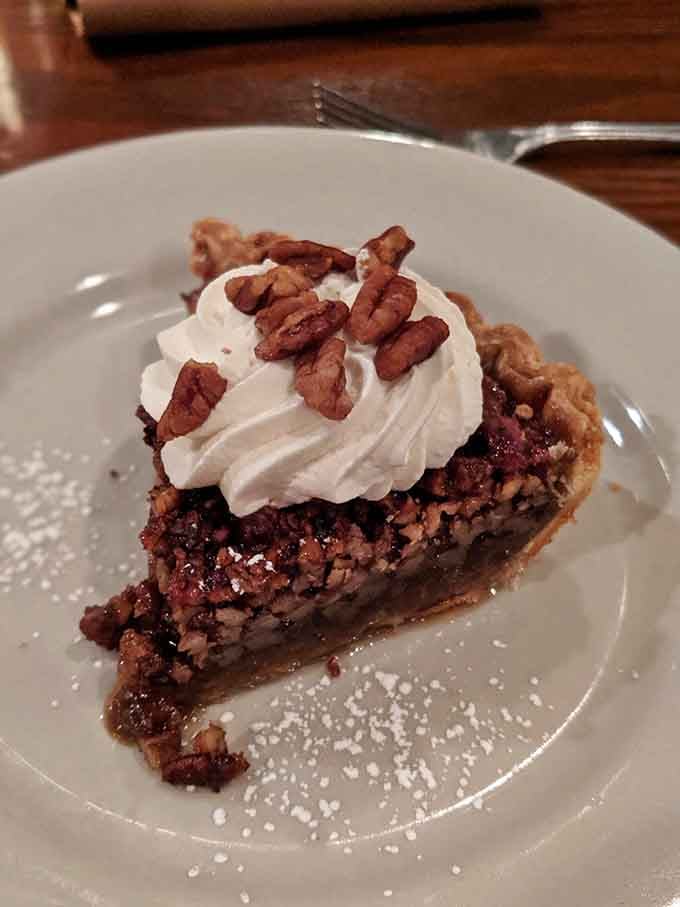 Pecan pie piled high with whipped cream and candied pecans, the kind of dessert that makes loosening your belt worthwhile.