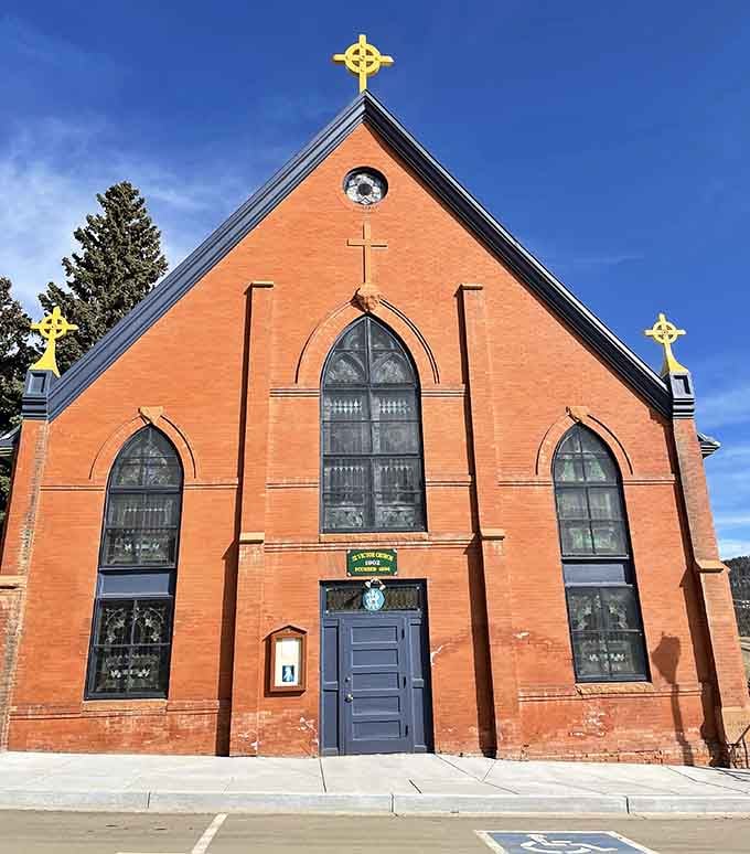 St. Victor Catholic Church stands in simple brick dignity, its golden crosses catching sunlight like beacons for the faithful and photographers.