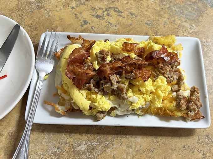 Scrambled eggs and bacon piled on crispy waffle base, because someone finally understood what breakfast really needed all along.