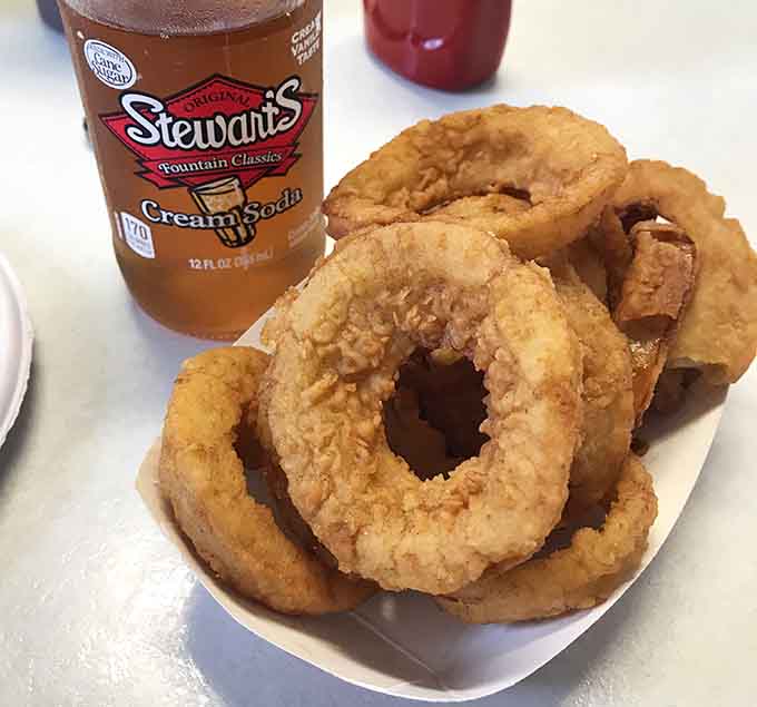 Hand-battered onion rings with golden, crispy coating that actually stays put where it belongs on the onion.