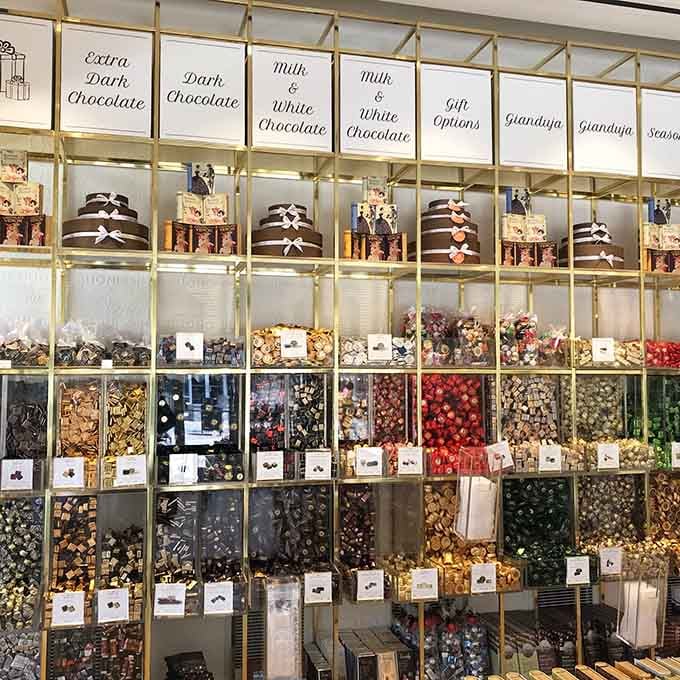 This chocolate wall resembles Willy Wonka's office supply closet, organized by cocoa percentage and pure temptation for sweet lovers.