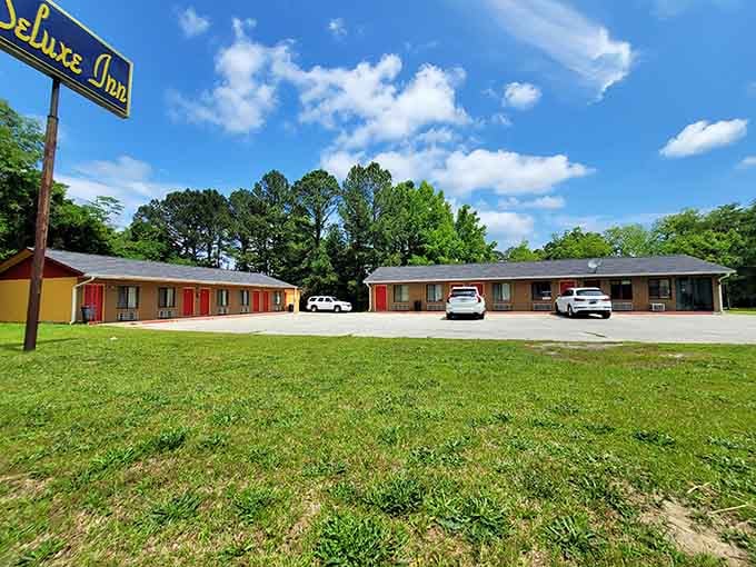 The Deluxe Inn's cheerful yellow sign promises clean sheets and the kind of rest you earn after honest work.