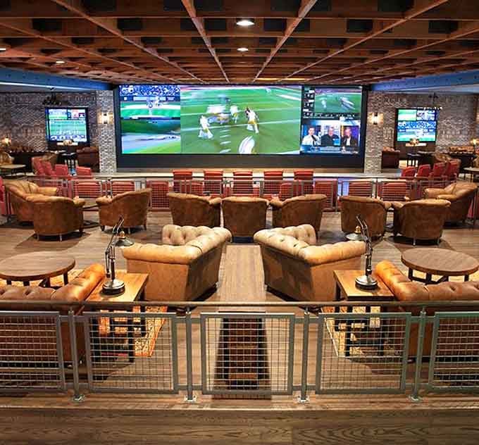 Leather chairs and massive screens create the ultimate sports viewing sanctuary for serious fans and casual bettors alike.