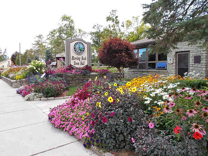 Flowers cascade in brilliant waves of pink, yellow, and red, proving small towns take their curb appeal seriously.