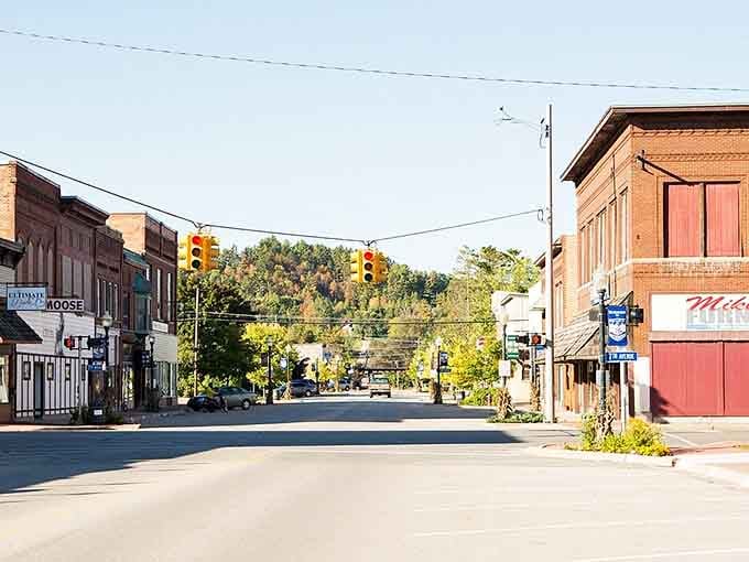 Morning light catches historic brick facades where traffic lights swing gently above streets that time hasn't forgotten or rushed.