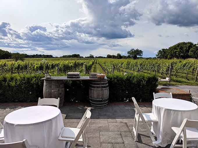 Wine barrels frame the patio where dramatic clouds promise an evening as memorable as the vintage.