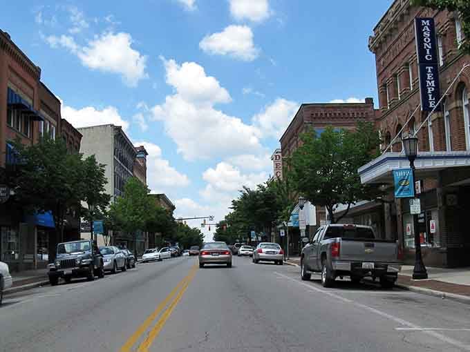 Brick facades stretch toward fluffy clouds in a scene that could be any decade from the last century.