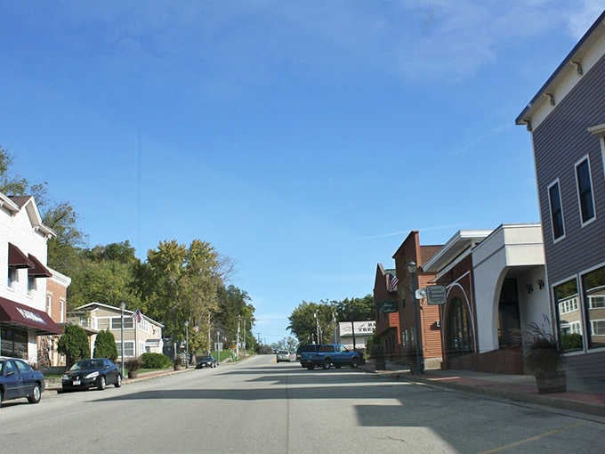 This peaceful street stretches toward distant trees, proving small towns know exactly when to end and let nature begin.