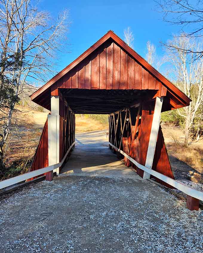 Sunlight streams through the covered bridge's interior, illuminating wooden planks that echo with footsteps and fond memories.