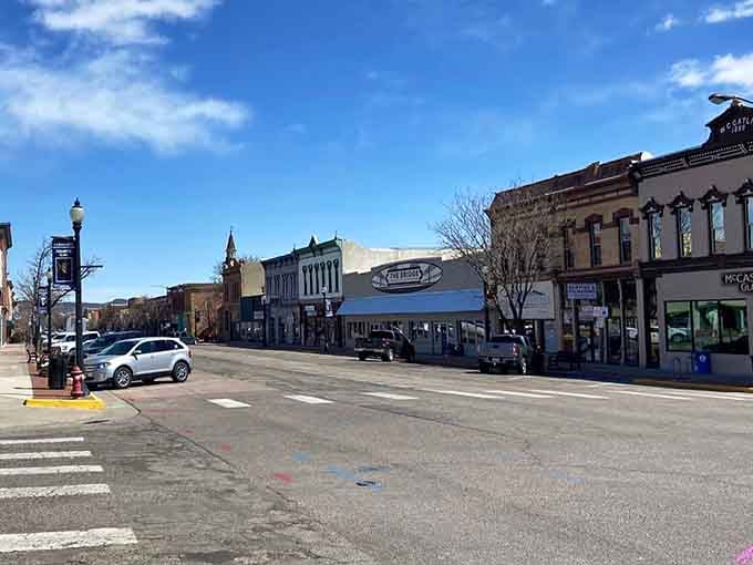 Wide main street stretches toward distant peaks where crosswalks lead to discoveries in this authentic Colorado town.