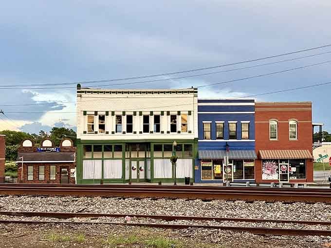 Railroad tracks running past colorful storefronts tell tales of when trains connected communities better than any internet ever could.