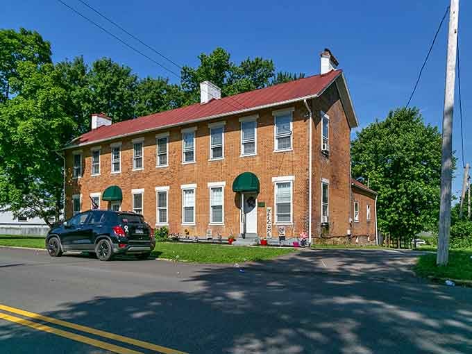 Classic brick architecture with green awnings offers timeless appeal, proving that some towns refuse to sacrifice character for convenience or cookie-cutter development.