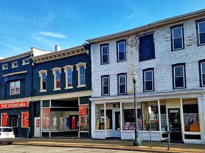 Painted storefronts in navy and white stand shoulder to shoulder like old friends sharing secrets on a quiet street.