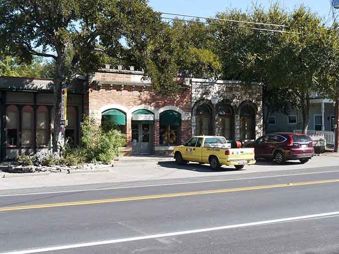 Those arched storefronts and shady trees make window shopping here feel like a leisurely stroll through a gentler era.