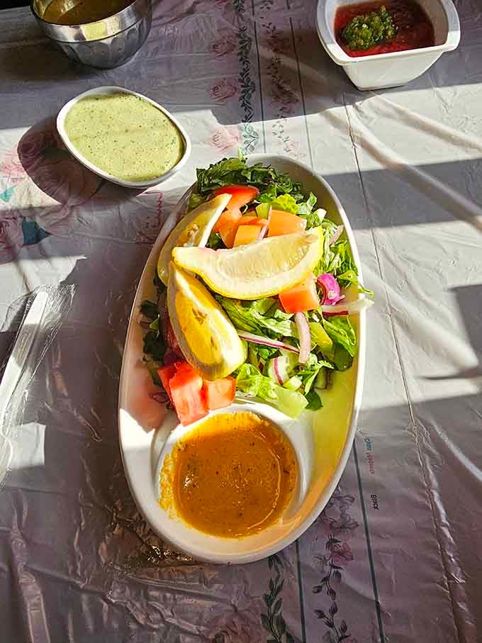 Fresh salad with lemon wedges and dressing, because even indulgent meals deserve a virtuous supporting character nearby.
