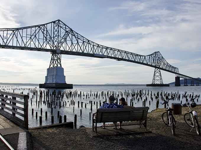 The Astoria-Megler Bridge dominates the skyline, with those old pilings creating a dramatic foreground for your photos.