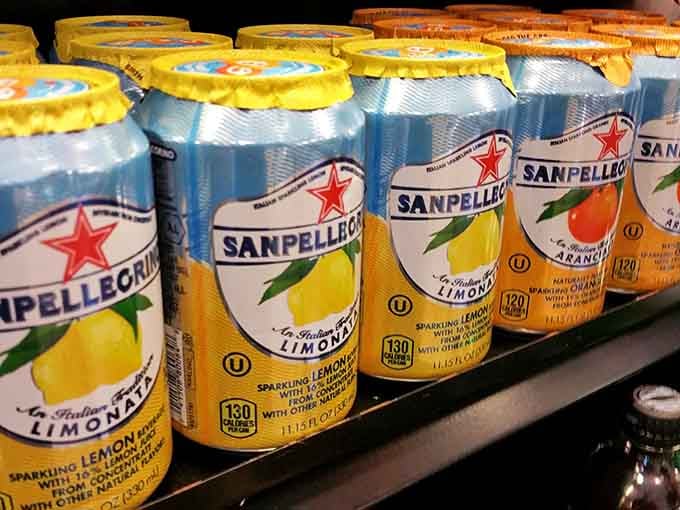 Sanpellegrino stands ready in cheerful rows, Italian sparkling refreshment to cleanse your palate between buffet trips.