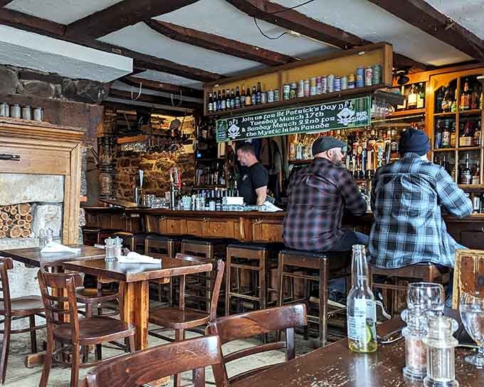 The rustic bar with exposed beams and stacked firewood feels like stepping into a Currier and Ives print come alive.