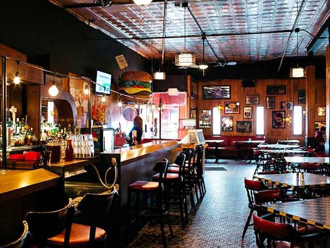 Warm lighting and classic bar stools create an inviting space where the tin ceiling reflects decades of good conversation.