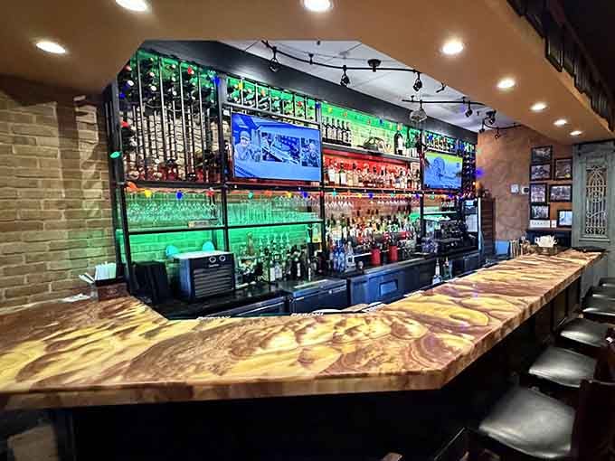 That gorgeous live-edge wood bar backed by colorful lighting, where craft cocktails meet Italian hospitality in perfect harmony.