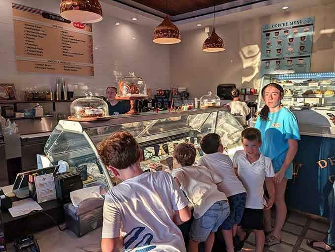 Young customers contemplating life's sweetest decisions while patient staff members prepare to make their sugary dreams come true.