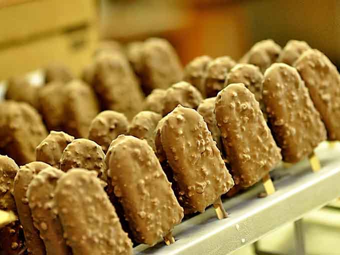 Rows of chocolate-covered ice cream bars stand at attention like delicious soldiers, each one promising frozen bliss on a stick.