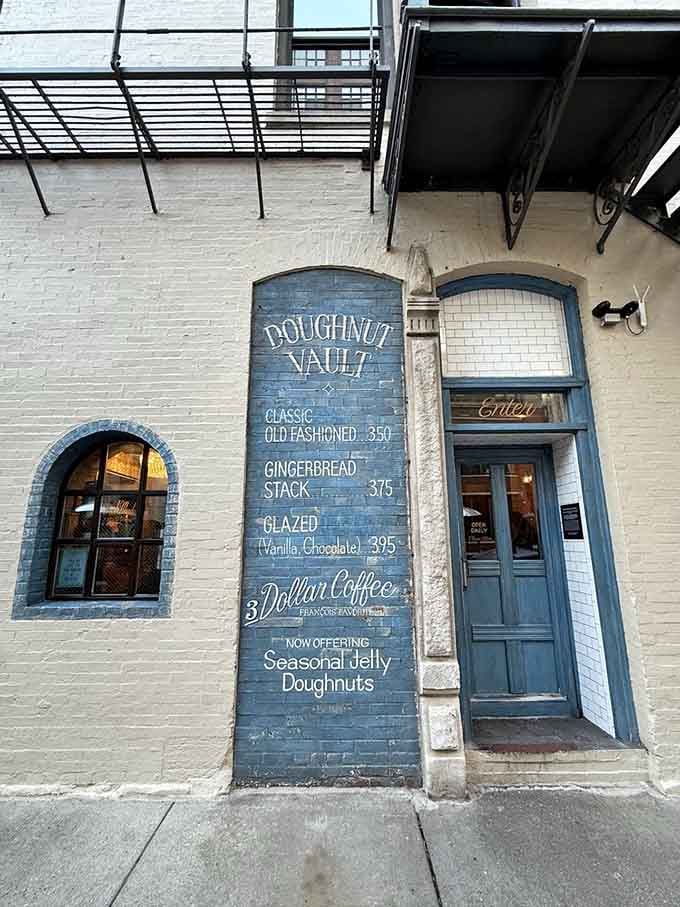 That painted brick menu tells you everything you need to know: fresh doughnuts, strong coffee, pure joy.