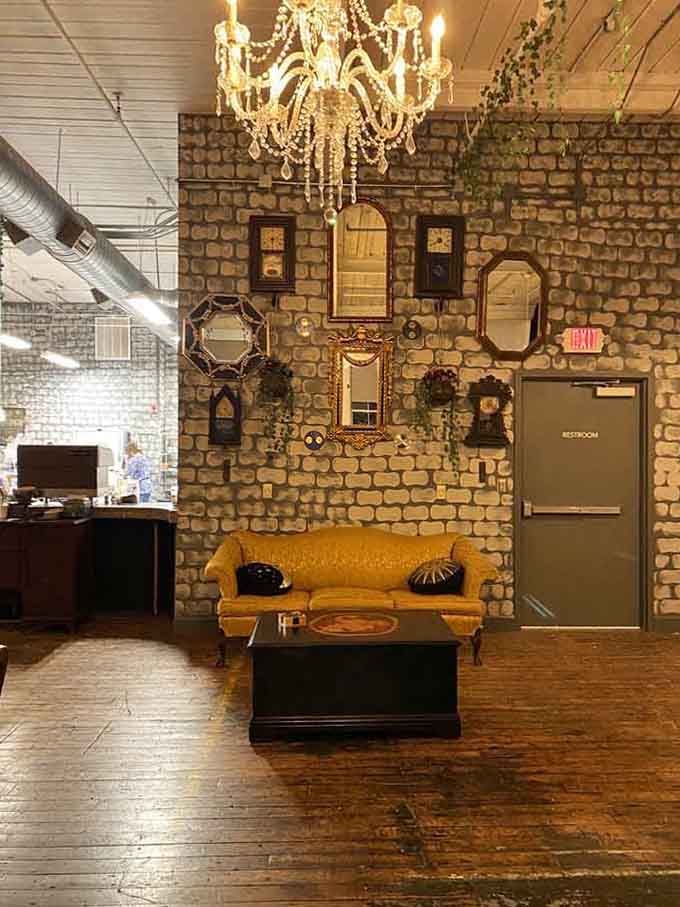 That brick wall adorned with vintage mirrors creates a cozy sitting area that invites you to stay awhile.