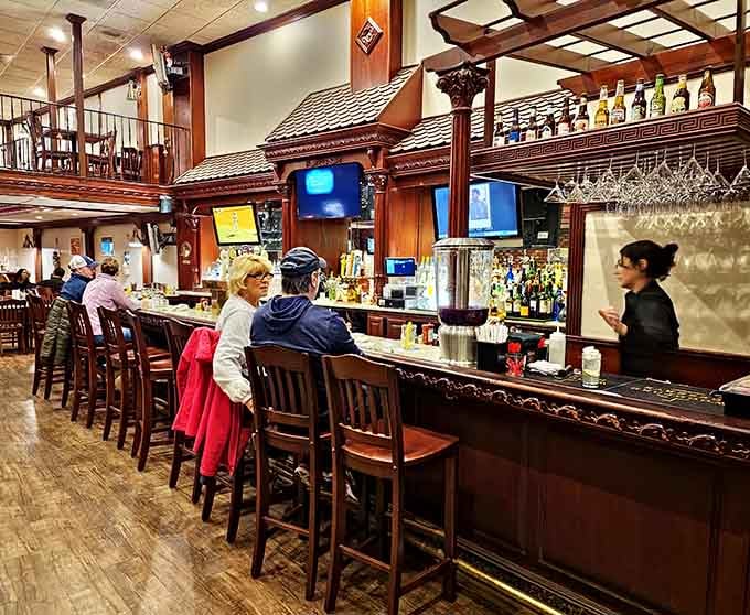 The bar area beckons with dark wood charm and enough bottles to make any pre-steak cocktail dreams come true.