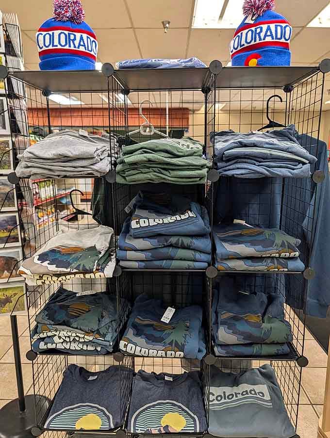 Colorado-themed apparel stacked high because sometimes you need a souvenir that isn't edible, though that's debatable.