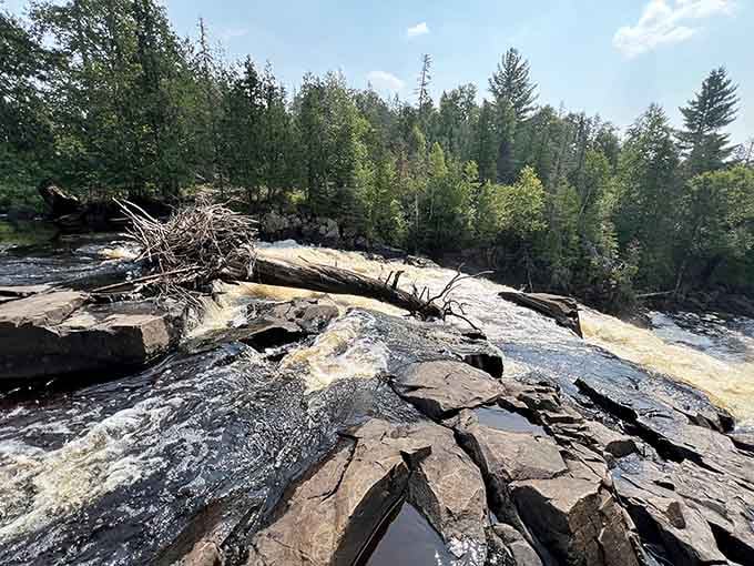 Water sheets over ancient volcanic rock, polished smooth by thousands of years of patient persistence.