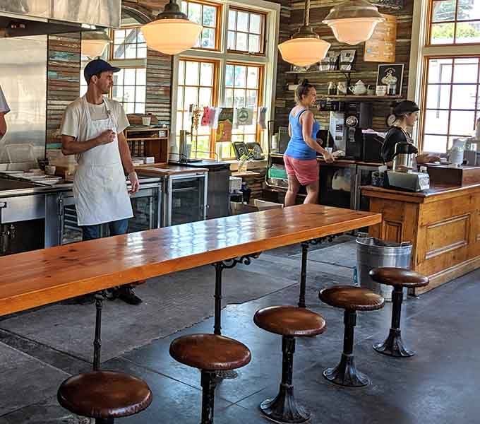 Rustic wooden tables and vintage stools invite you to slow down and actually enjoy your food like civilized humans.