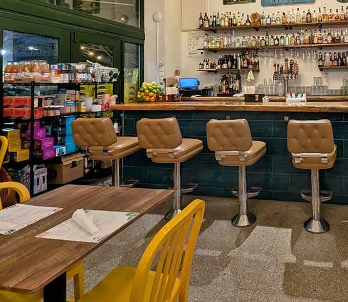 The bar area blends retro diner stools with island spirit, creating the coolest spot to wait for your order.