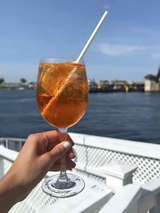 An Aperol spritz held against the marina backdrop captures everything right about summer drinking by the Jersey Shore water.