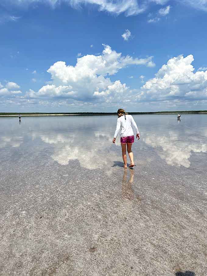 One brave soul wades into the shallow water where sky and earth become indistinguishable from each other.