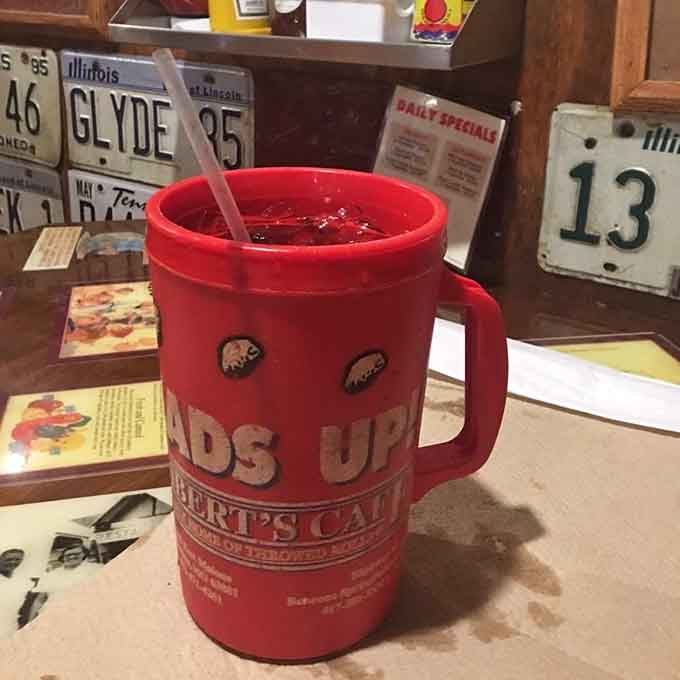 The red collectible cup surrounded by vintage license plates perfectly captures the Americana spirit that makes this place feel like home.