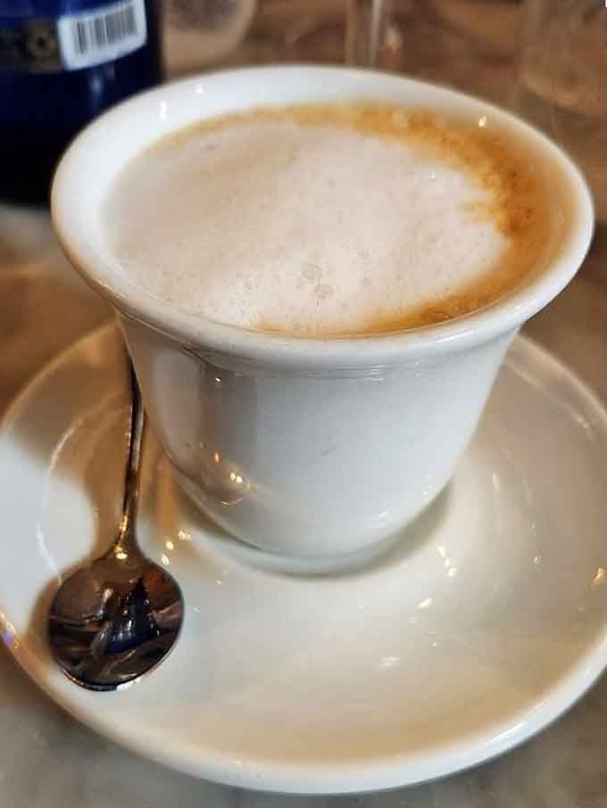 A cappuccino so perfectly foamed it deserves its own Instagram account, served with a tiny spoon of elegance.