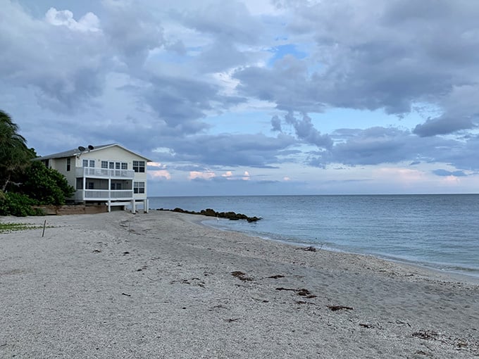 A beachfront home catches the last light of day, positioned perfectly for sunset watching with cocktail in hand.