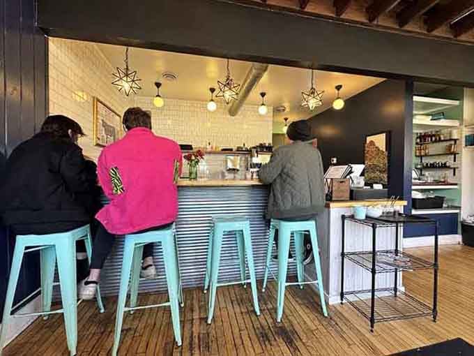 Turquoise bar stools and corrugated metal create a hip vibe where coffee tastes better and morning conversations flow easier than expected.