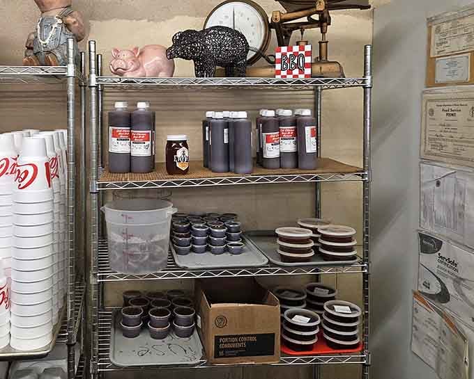 Shelves lined with sauce containers and pig decorations show a kitchen that takes its barbecue business seriously and proudly.